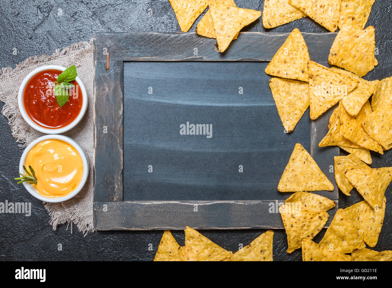 Mexican nacho with sauces and chalk board on black background, top view ...
