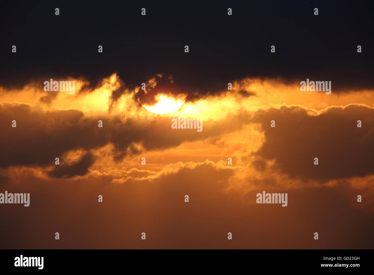 The setting sun with dark clouds Stock Photo - Alamy