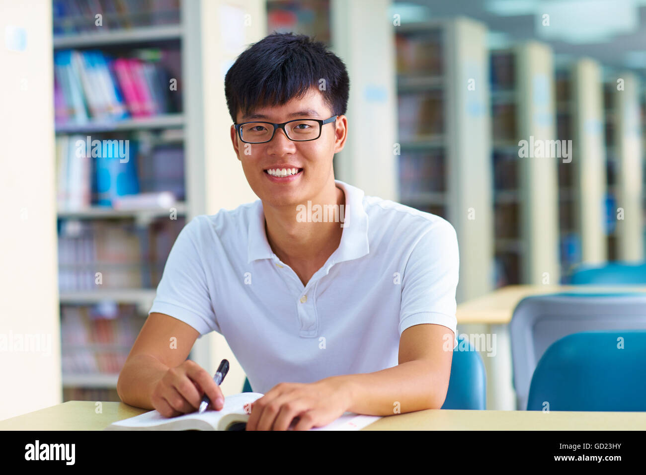 one young asian or Chinese College male students holding a book and ...
