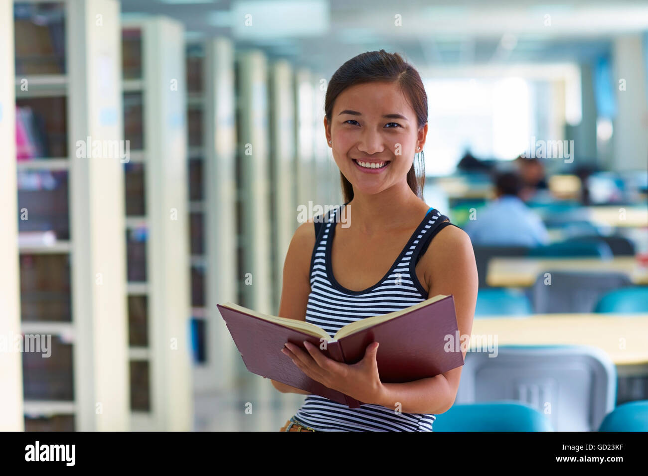 one pretty young Asian or Chinese college student study in the library ...