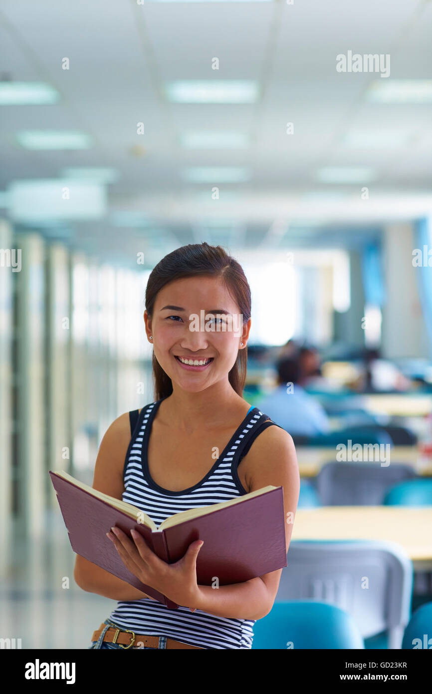 one pretty young Asian or Chinese college student study in the library ...