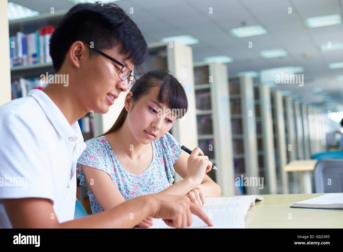 Young asian or Chinese college students study together in the library ...