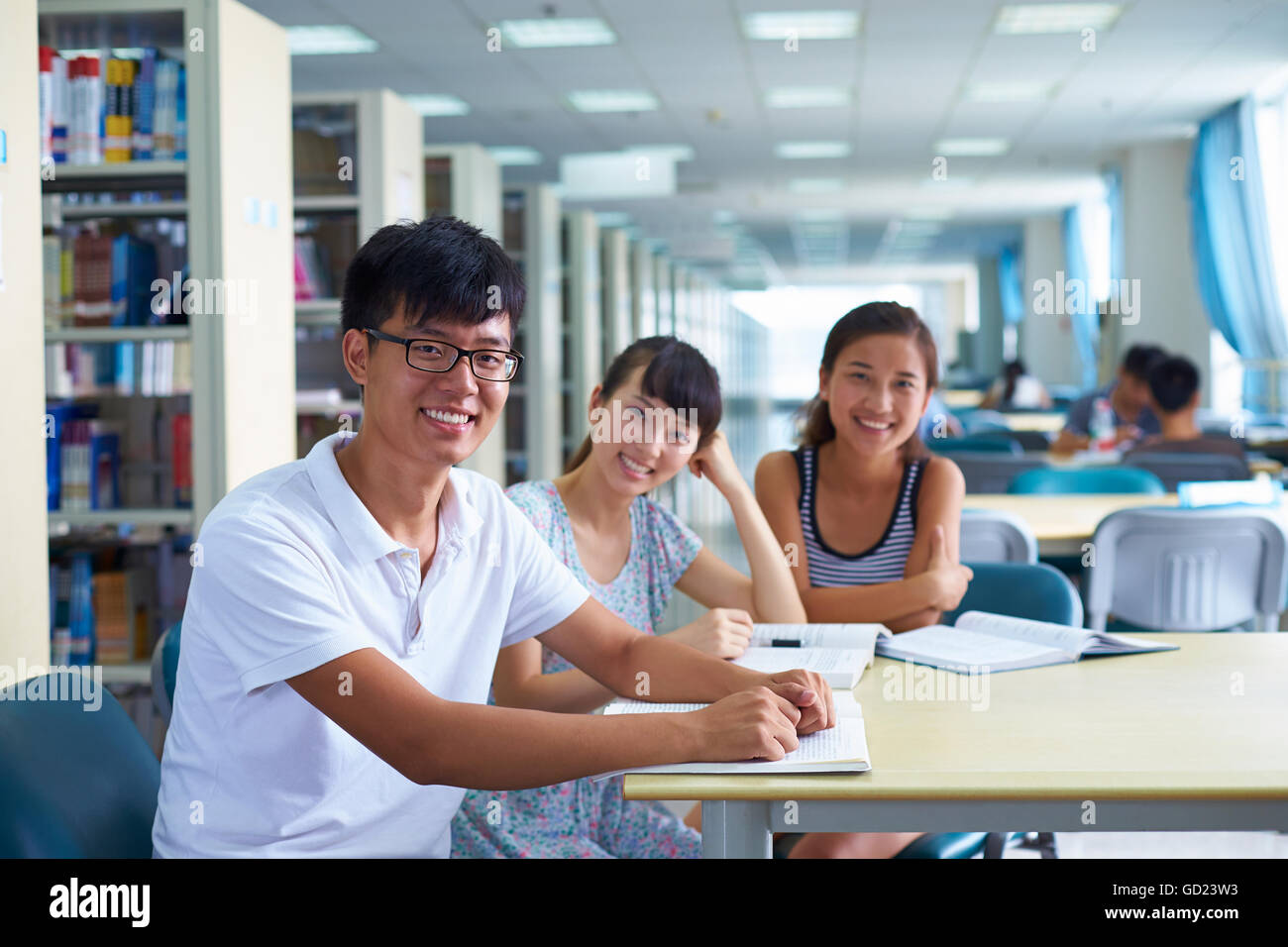 Young asian or Chinese college students study together in the library ...