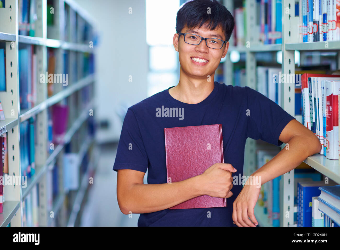 one young asian or Chinese College male students holding a book and ...