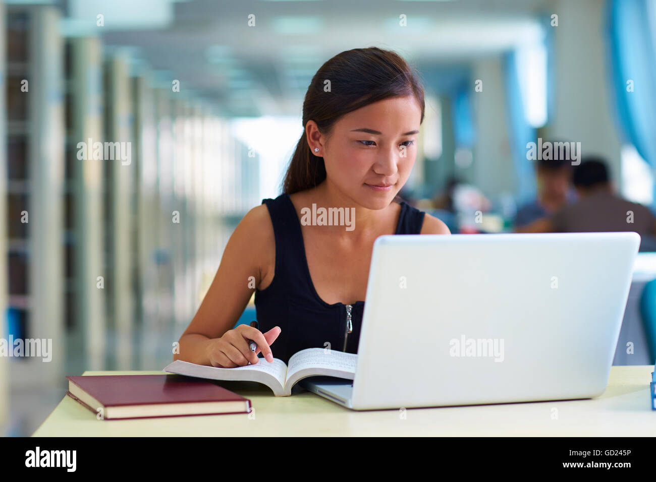 one pretty young Asian or Chinese college student study in the library ...