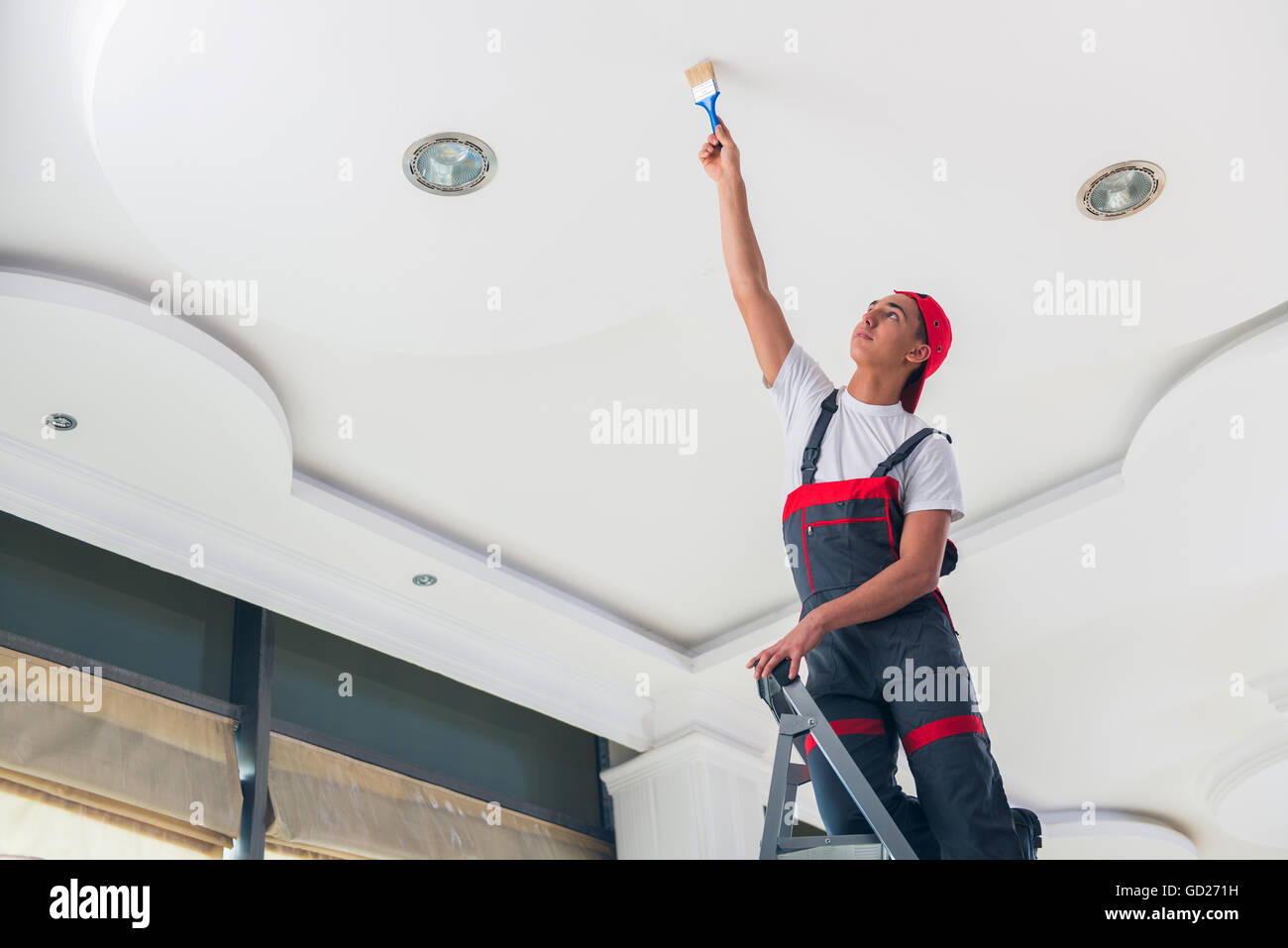 Young painter painting the ceiling in construction concept Stock Photo ...