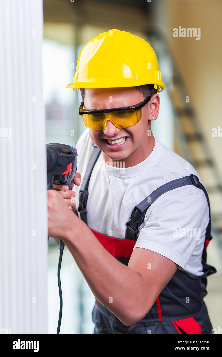 Man drilling the wall with drill perforator Stock Photo - Alamy