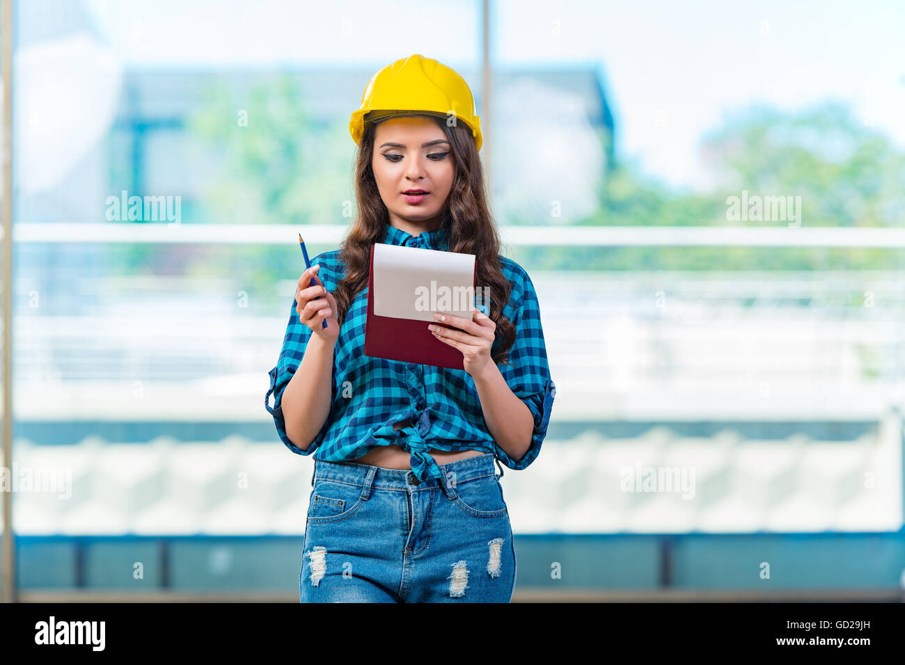 Woman builder taking notes at construction site Stock Photo - Alamy