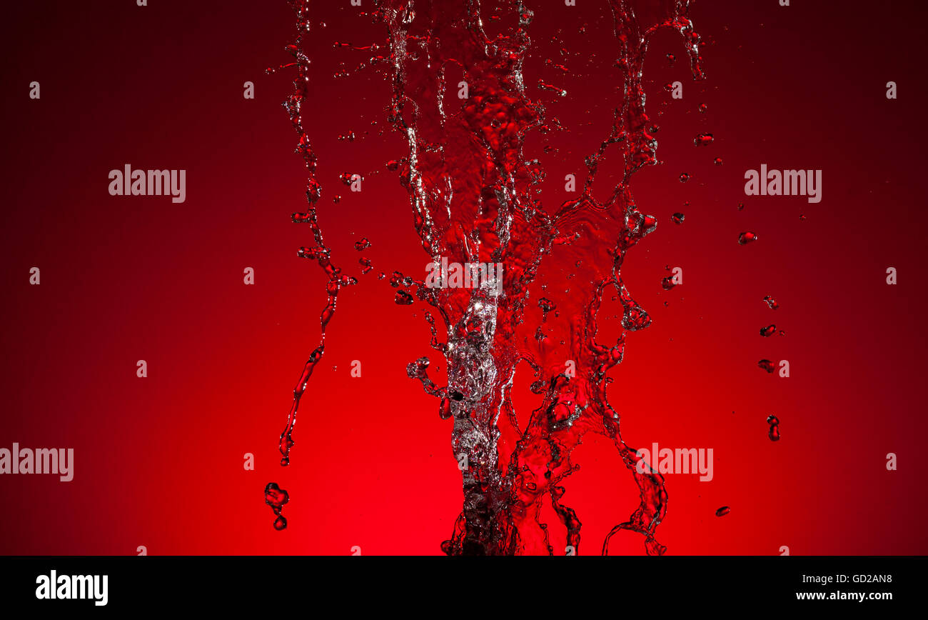 Water splashes on a red background Stock Photo - Alamy