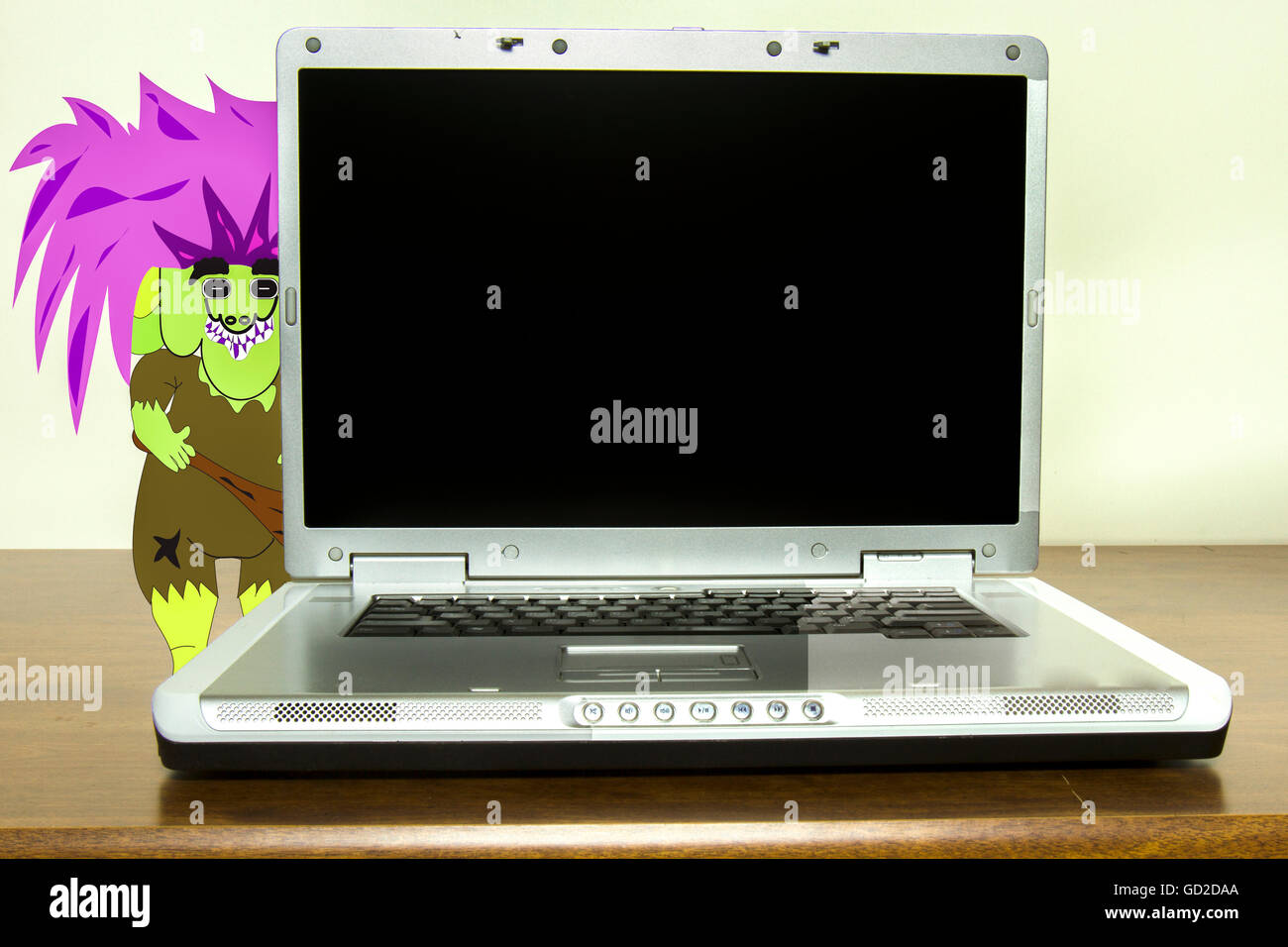 Illustrated mountain troll standing behind laptop computer on a desktop ...