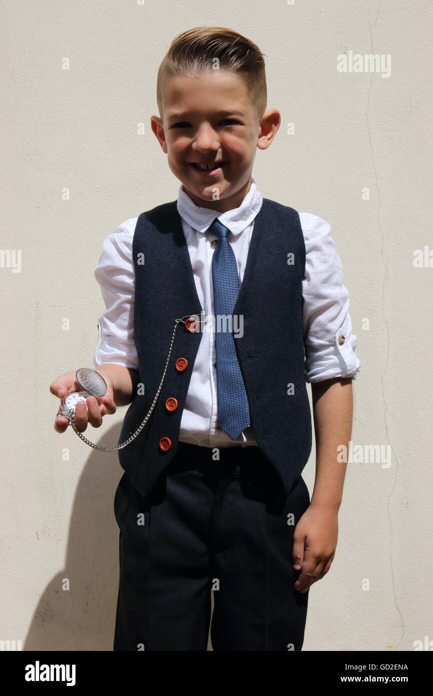 A young boy looking smart wearing a suit and holding a pocket watch for ...