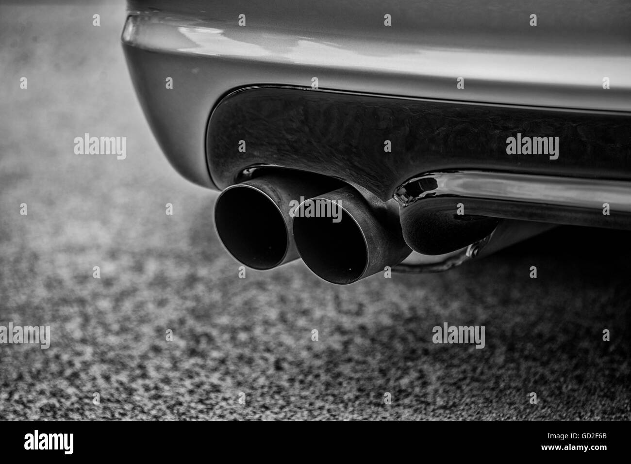 Double exhaust pipes of a modern sports car, black and white Stock ...