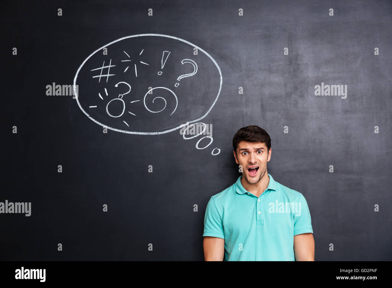 Confused shocked young man thinking about problem with blackboard ...
