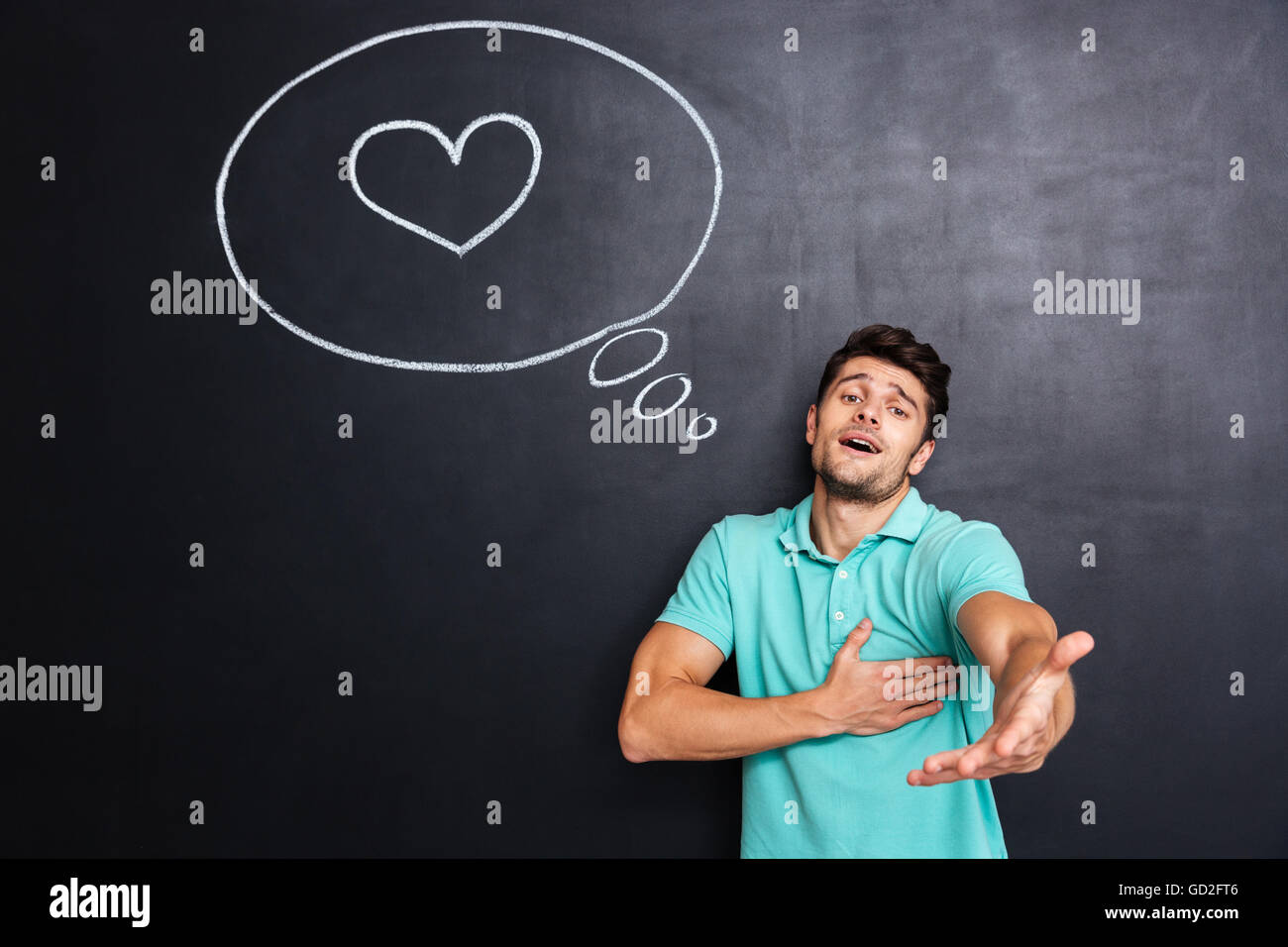 Handsome young man in love giving you his hand over chalkboard ...