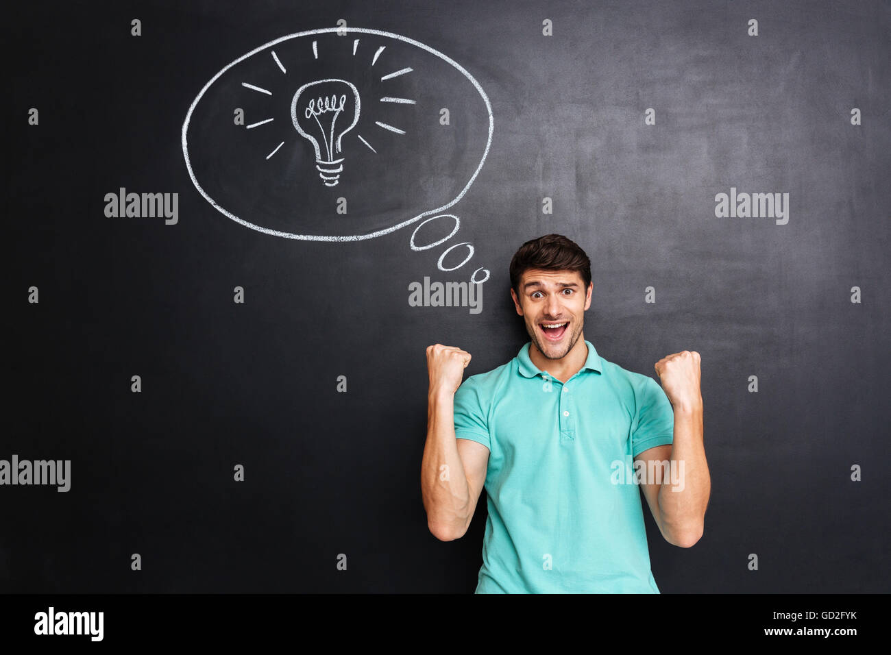 Cheerful successful young man having an idea and celebrating success ...