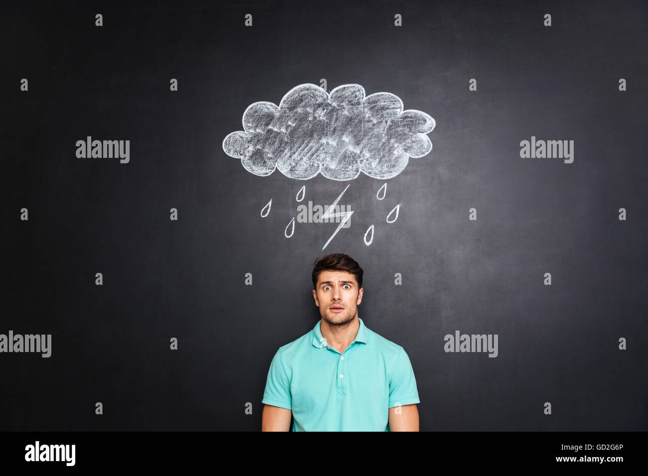 Surprised astonished young man standing under raincloud with lightning ...