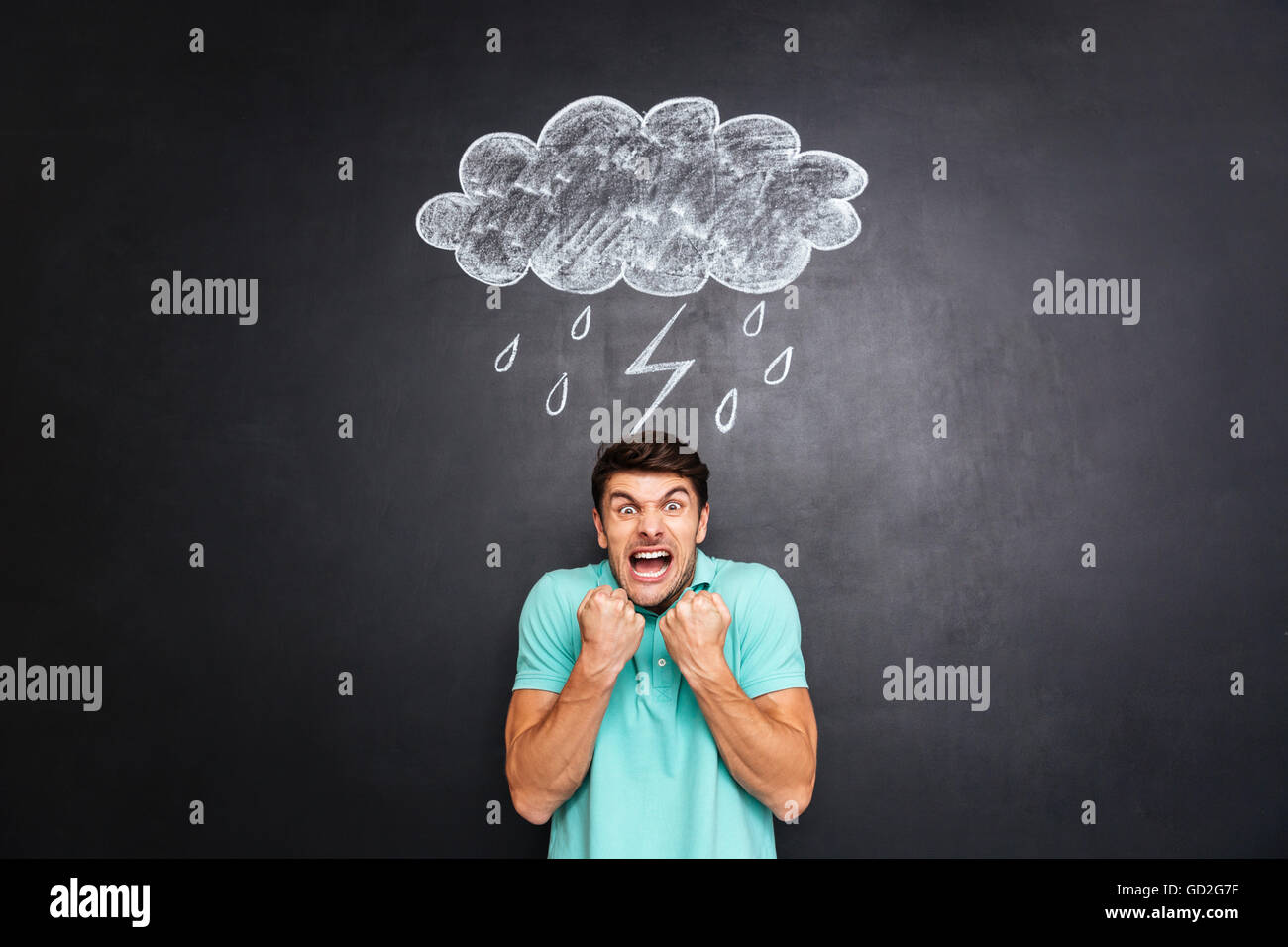 Mad irritated young man standing under drawn raincloud with lightning ...