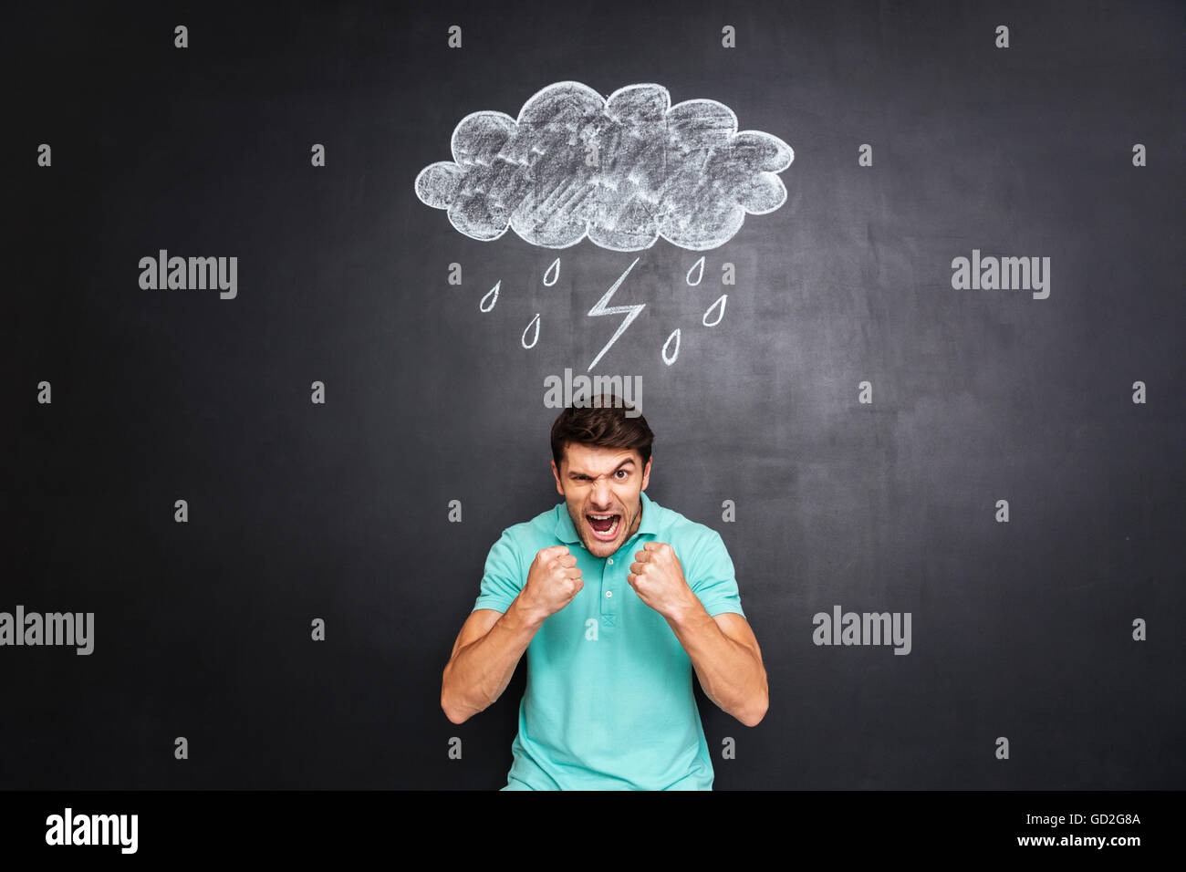 Angry furious young handsome man yelling over background of chalkboard ...