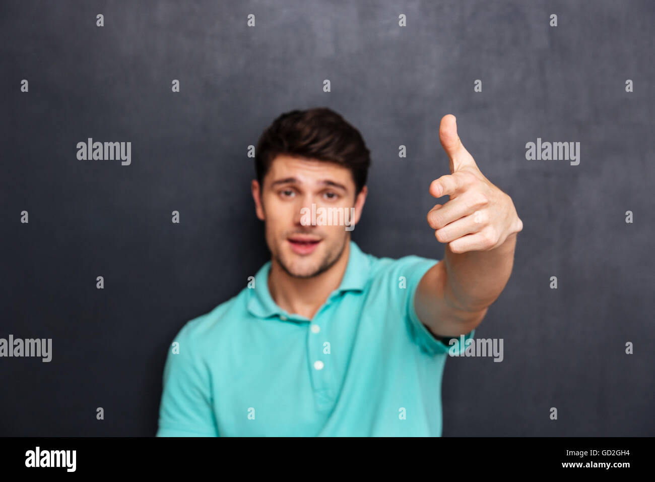 Portrait of a handsome man pointing finger at camera isolated on a ...