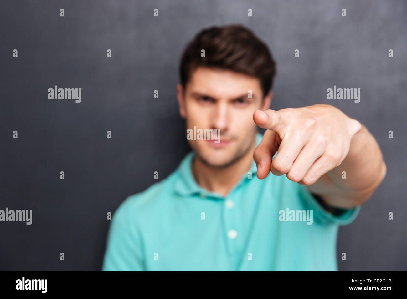 Close up portrait of a handsome man pointing finger at camera isolated ...