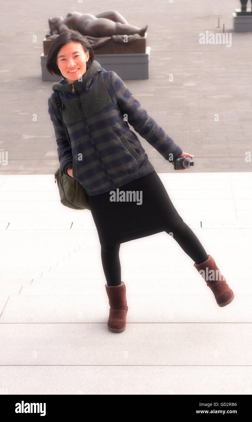 A chinese woman balancing on one foot in front of the China Art Museum ...