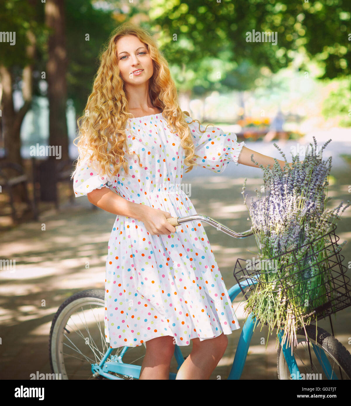 Beautiful and happy young woman on bicycle on the summer park in ...