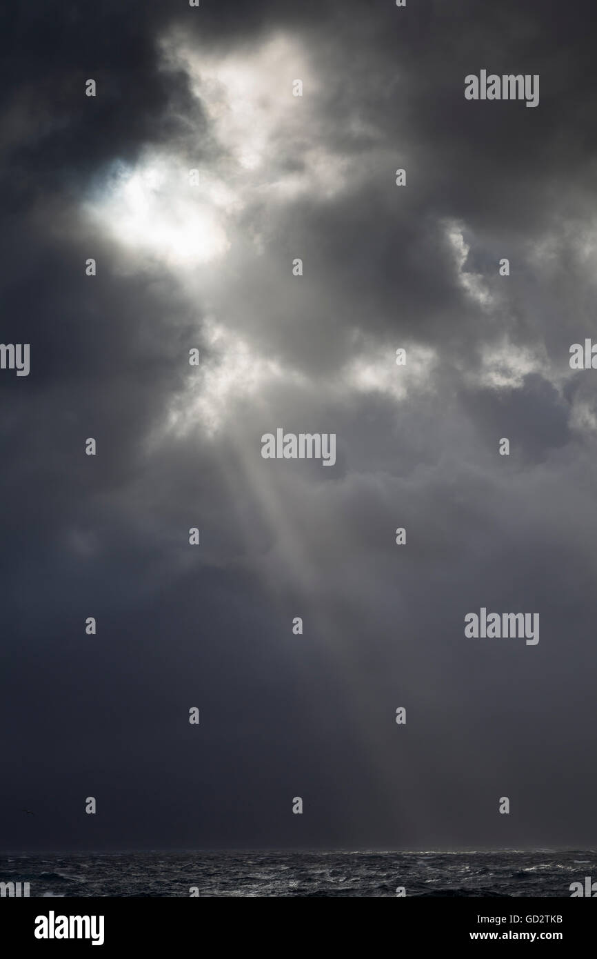 Sun rays breaking through heavy storm clouds in the Foveaux Strait, New ...