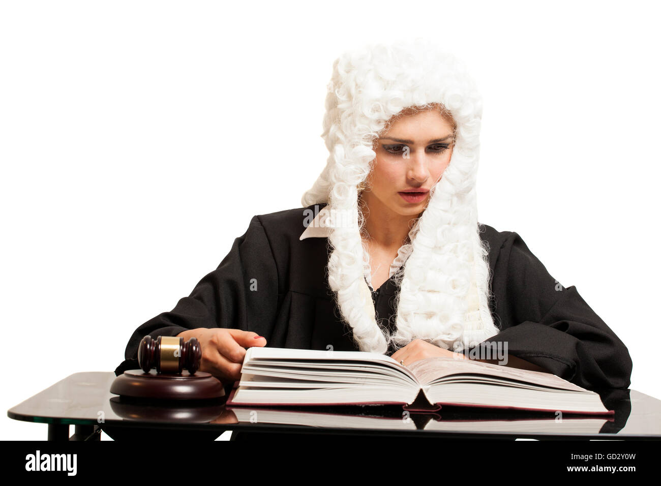 Female judge wearing a wig and black mantle with judge gavel and book ...