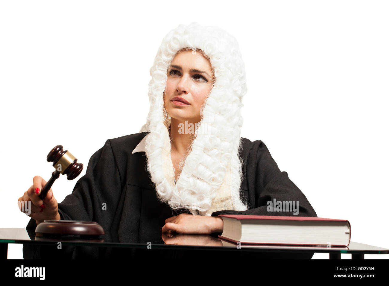 Female judge wearing a wig and black mantle with judge gavel and book ...