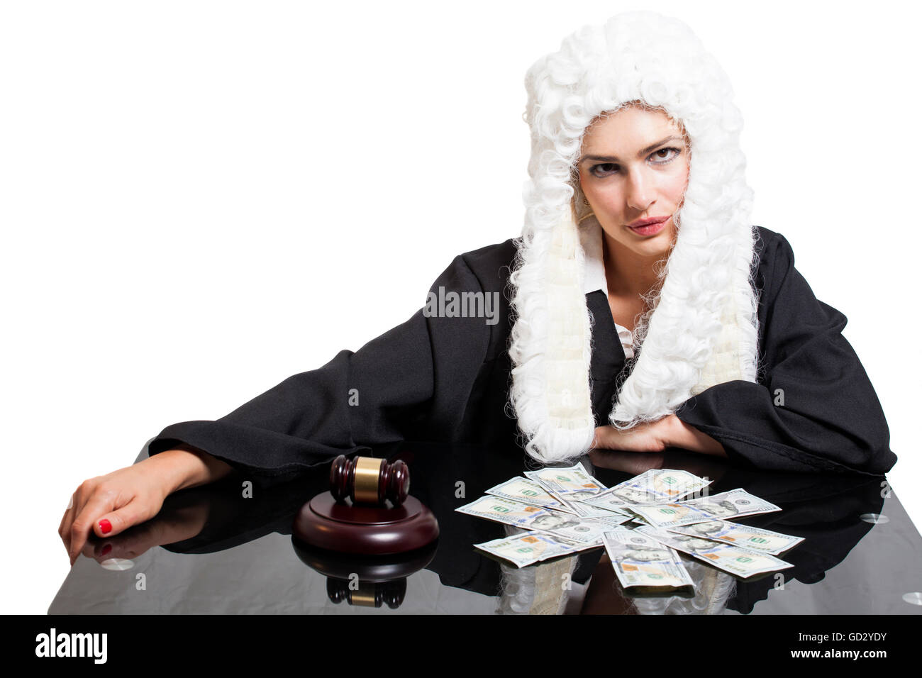 Female corrupt judge with gavel and money at table isolated on white ...