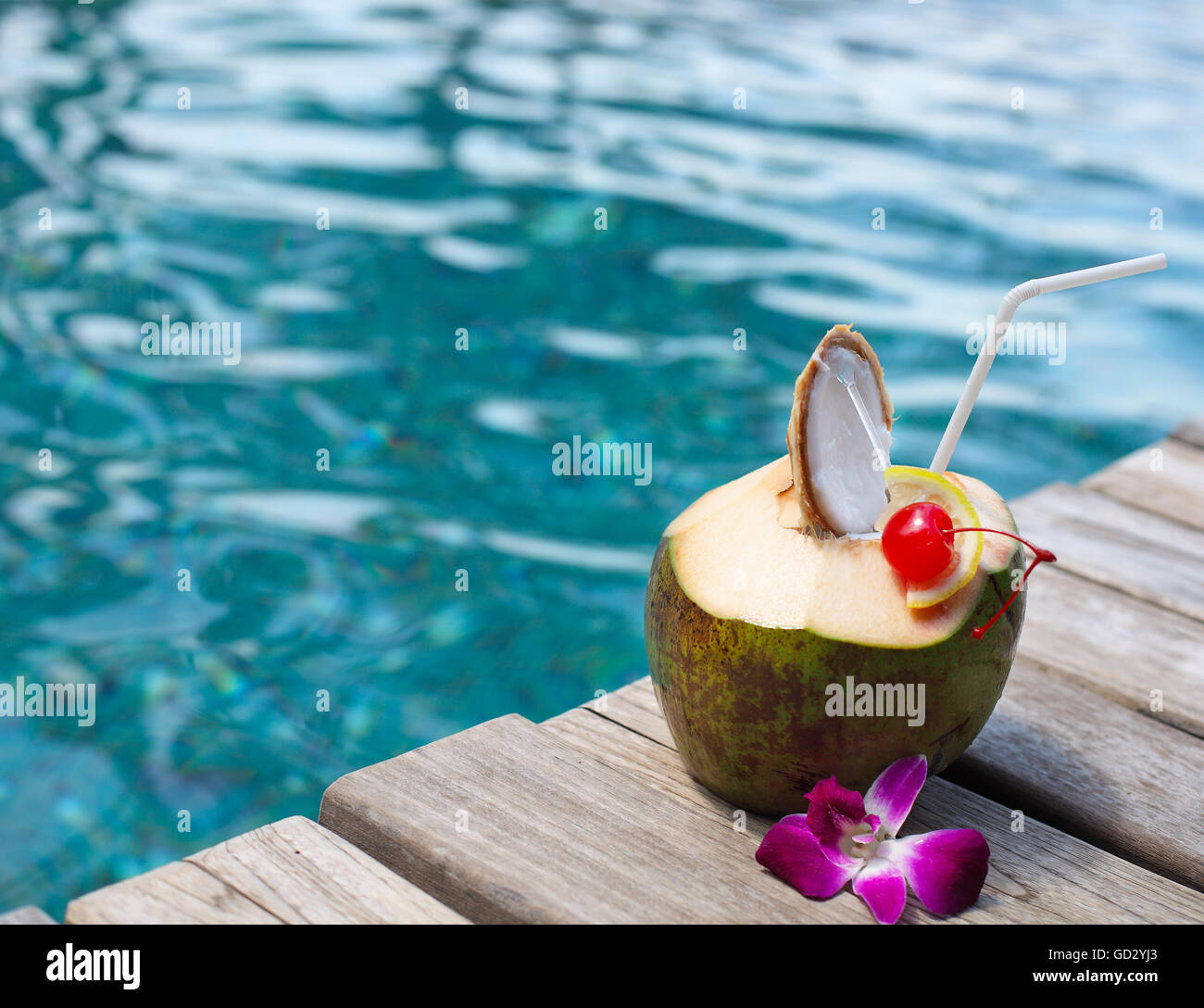 Coconut cocktail with drinking straw by the swimming pool Stock Photo ...