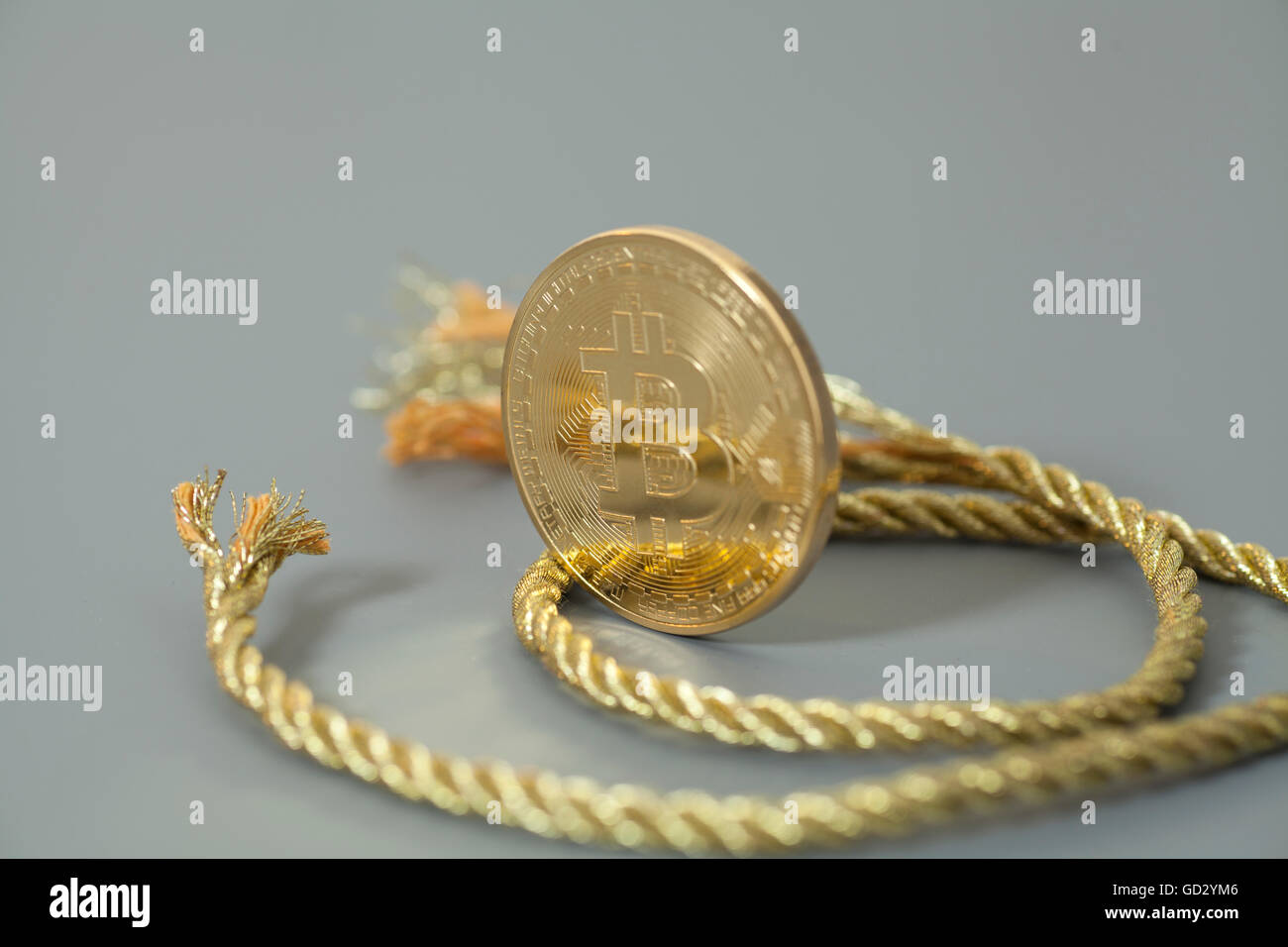 Golden Bitcoin coin with golden rope isolated on gray background Stock ...