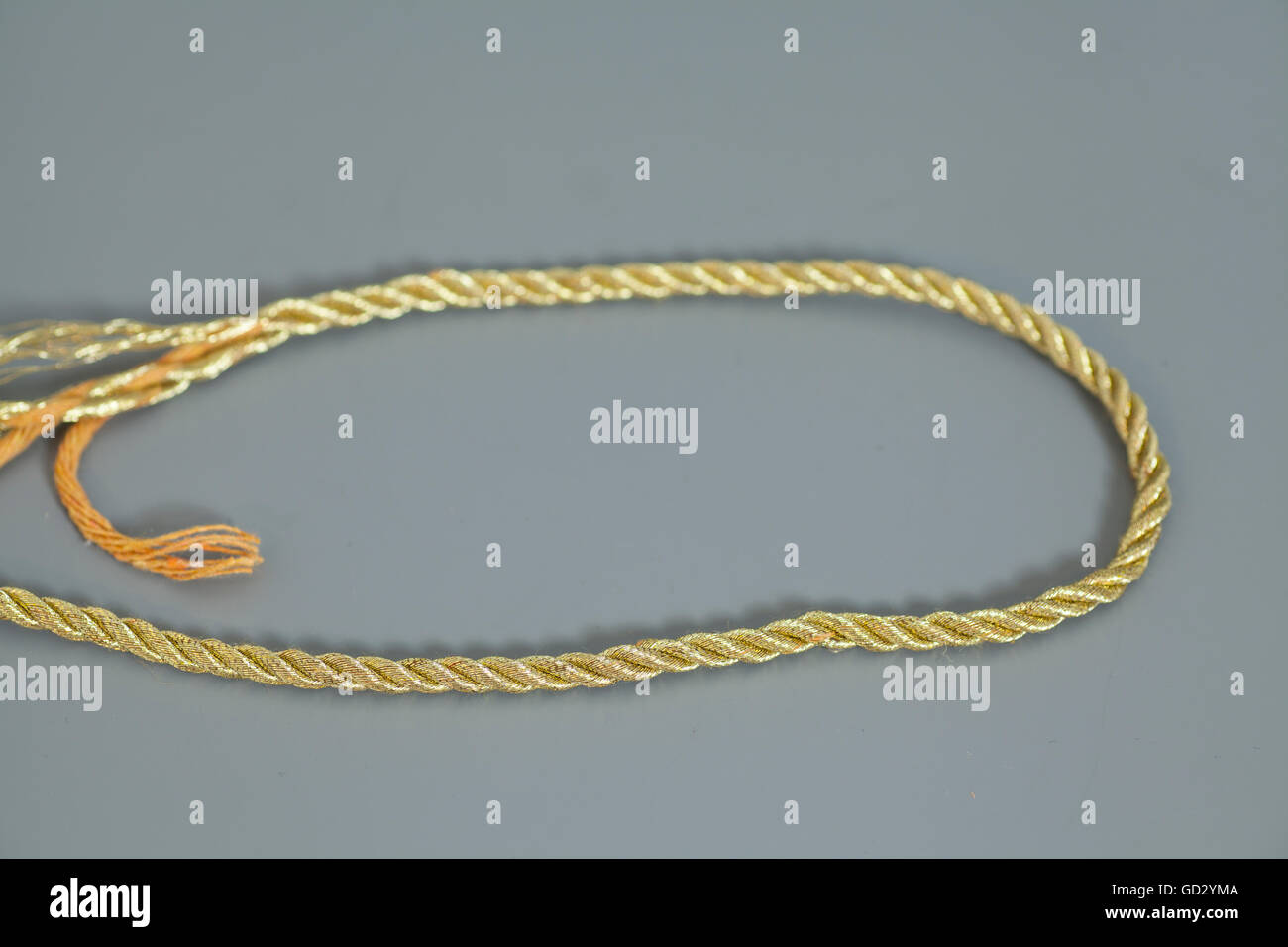 Golden rope isolated on gray background Stock Photo - Alamy