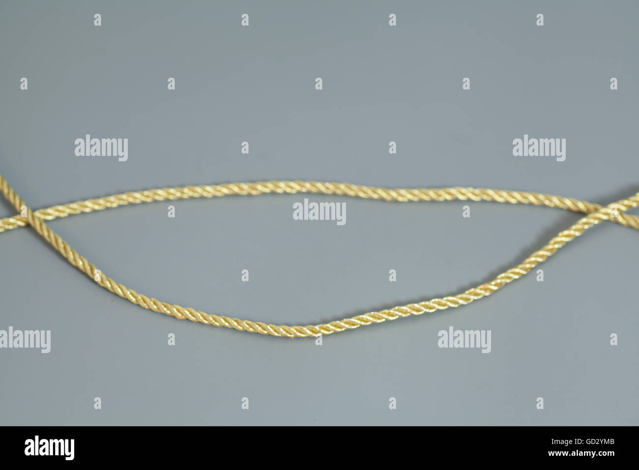 Golden rope isolated on gray background Stock Photo - Alamy
