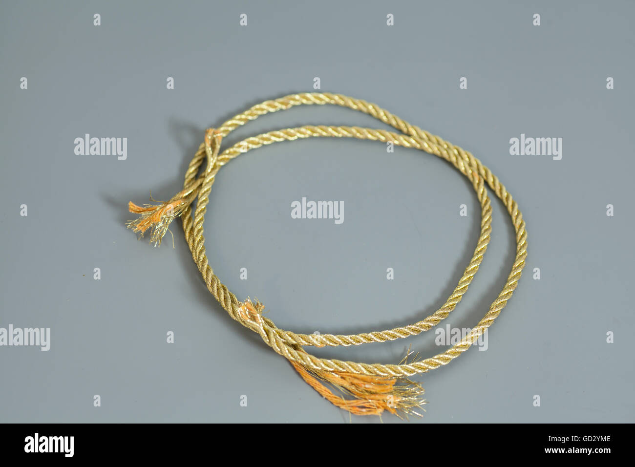 Golden rope isolated on gray background Stock Photo - Alamy