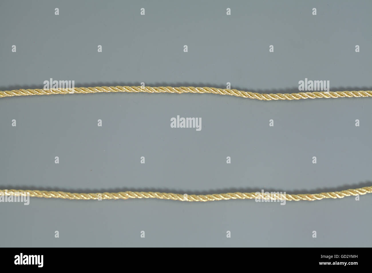 Golden rope isolated on gray background Stock Photo - Alamy