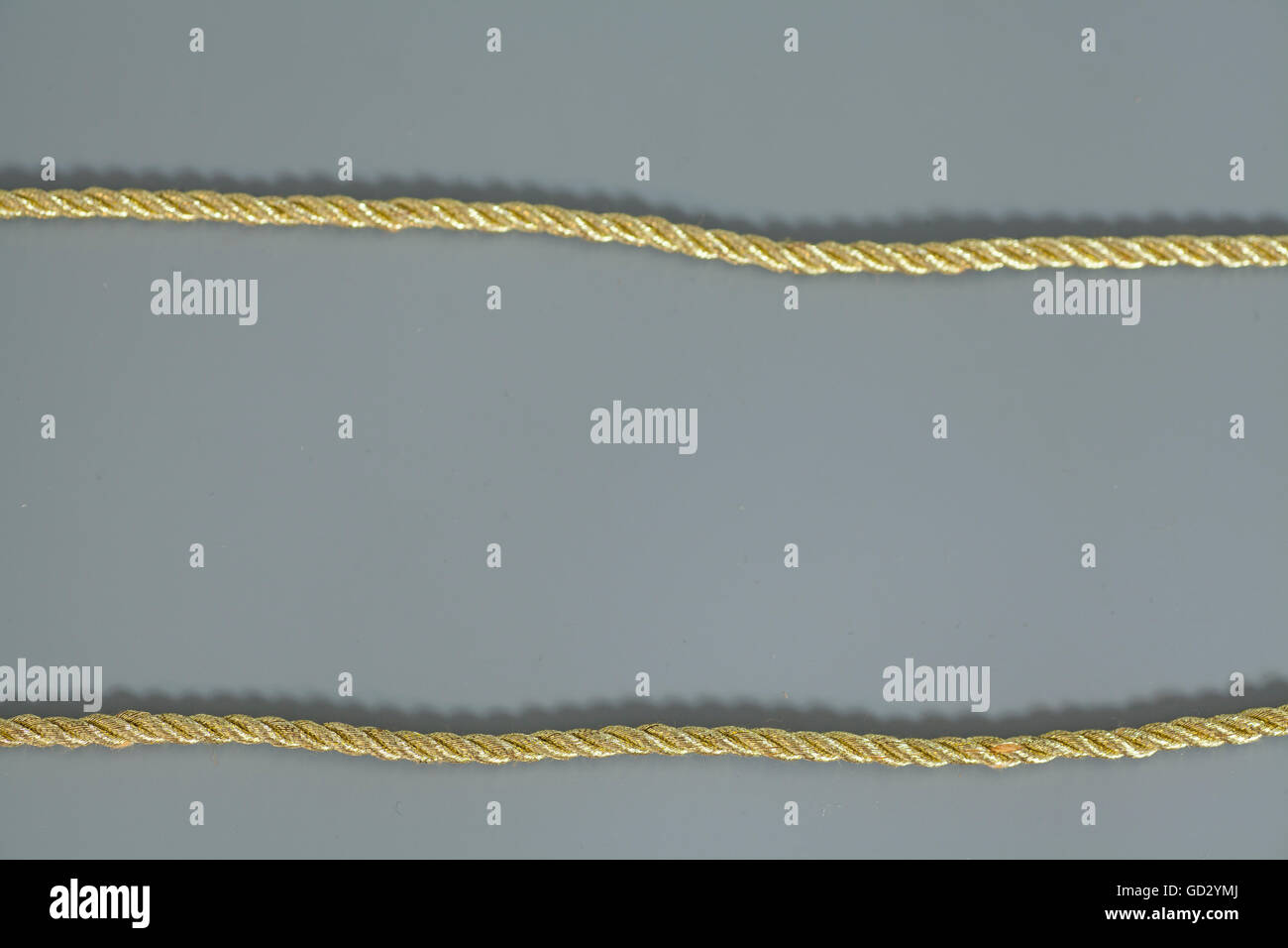 Golden rope isolated on gray background Stock Photo - Alamy