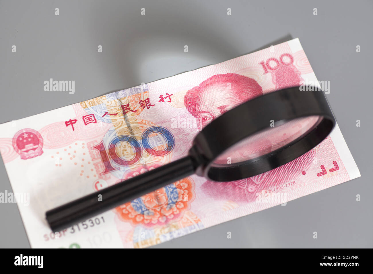 Yuan chinese money with magnifier glass isolated on gray Stock Photo ...