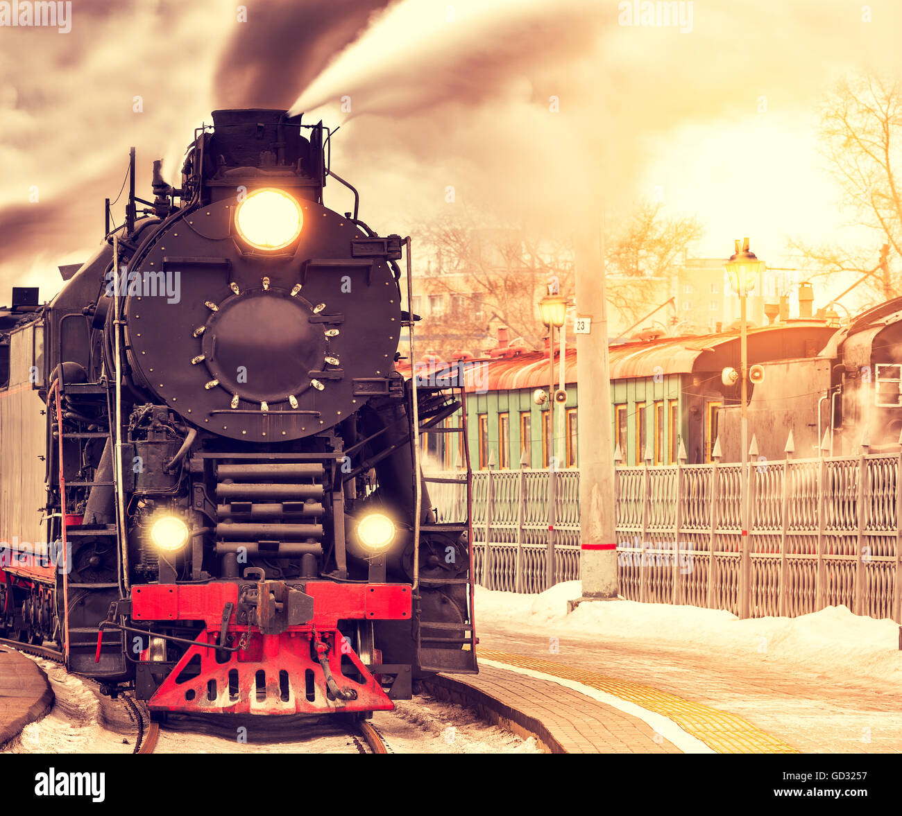 Arrival of the retro steam train at sunset time Stock Photo - Alamy