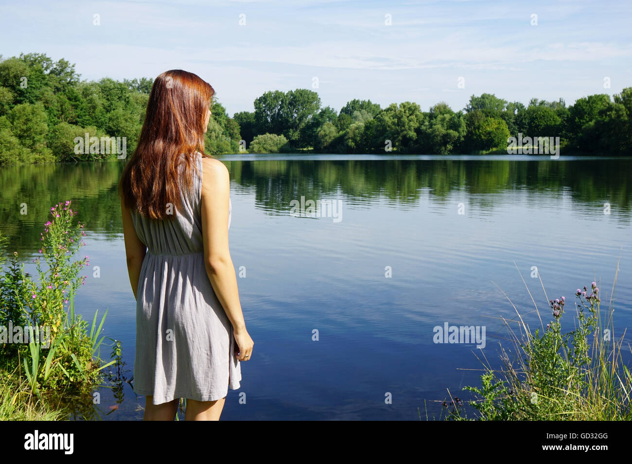 young woman looking over idyllic lake Stock Photo - Alamy