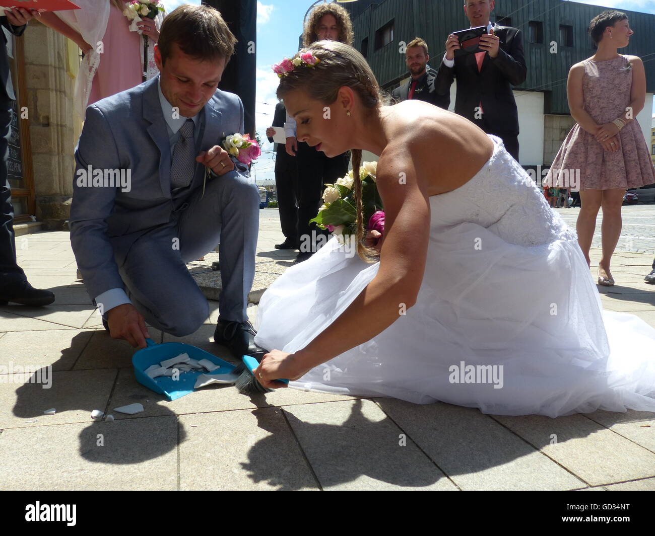 bride and groom pick up pieces of broken plate, a long year tradition ...