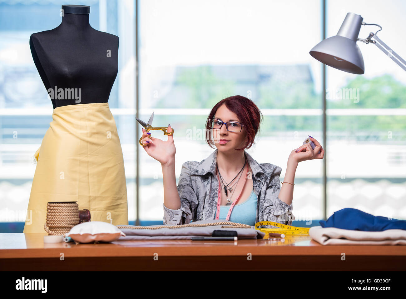 Woman tailor working at her desk Stock Photo - Alamy