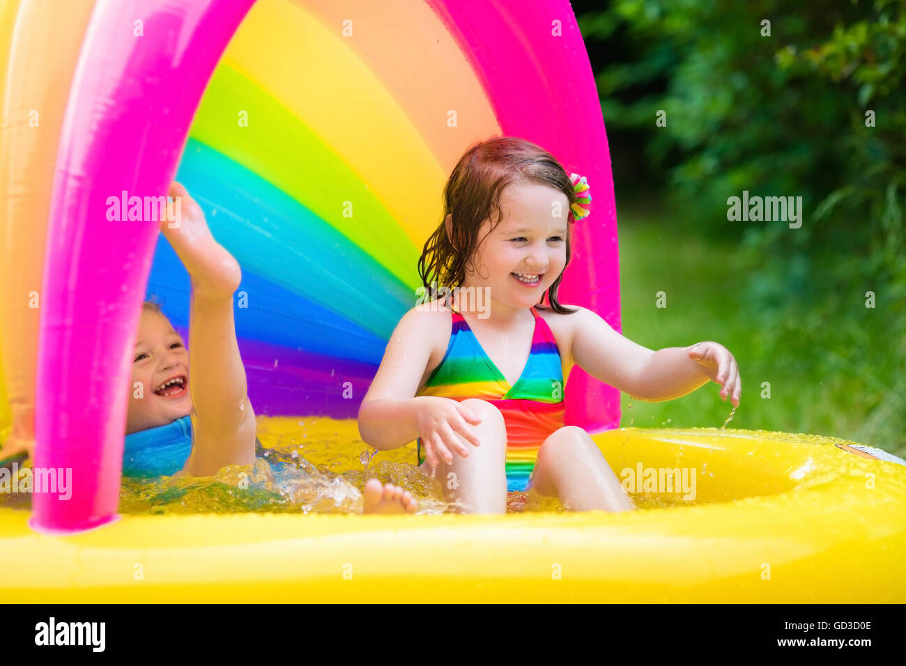 Children playing in inflatable baby pool. Kids swim and splash in ...