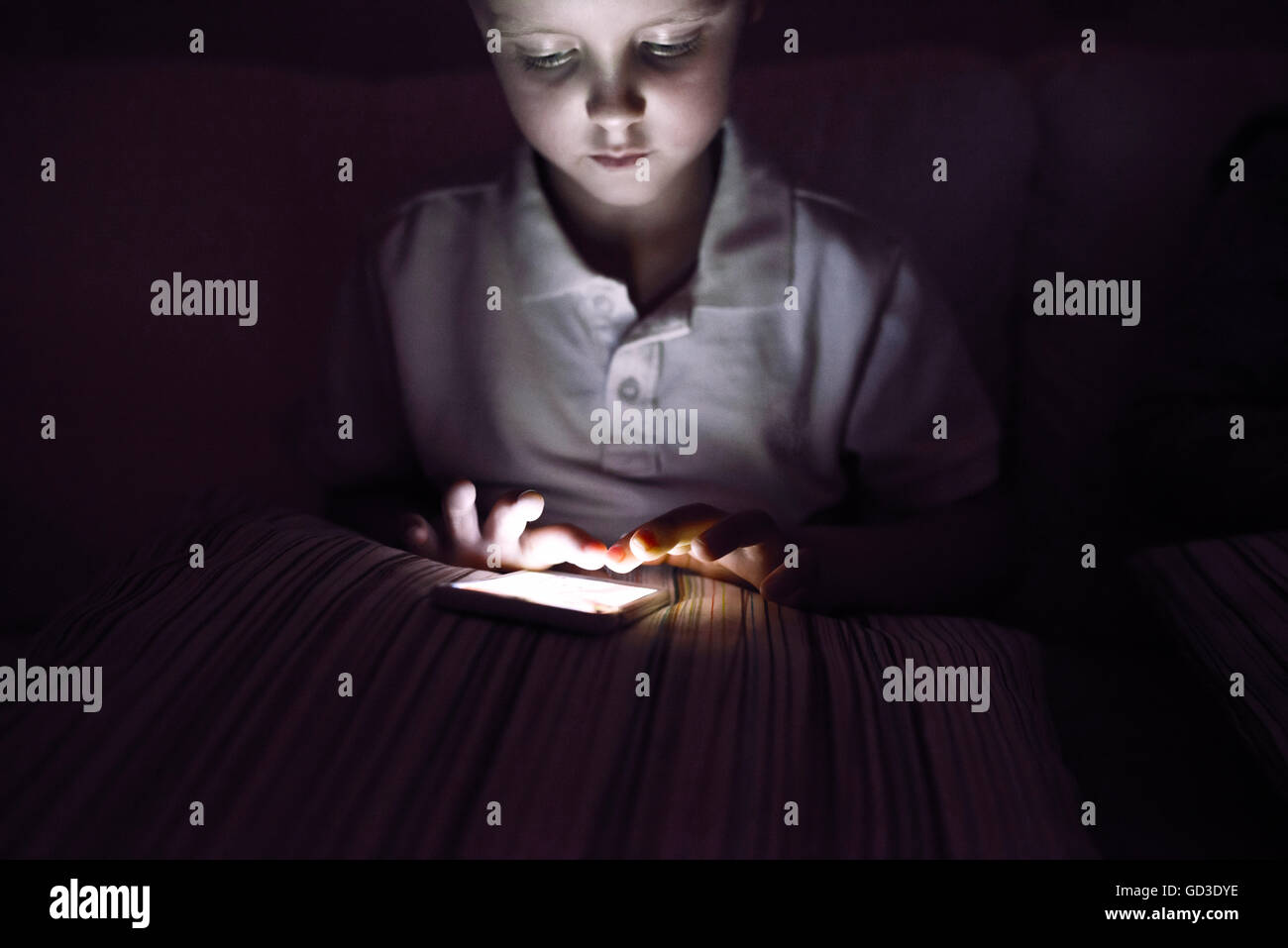 Little boy, sitting in a dark, playing with smartphone Stock Photo - Alamy