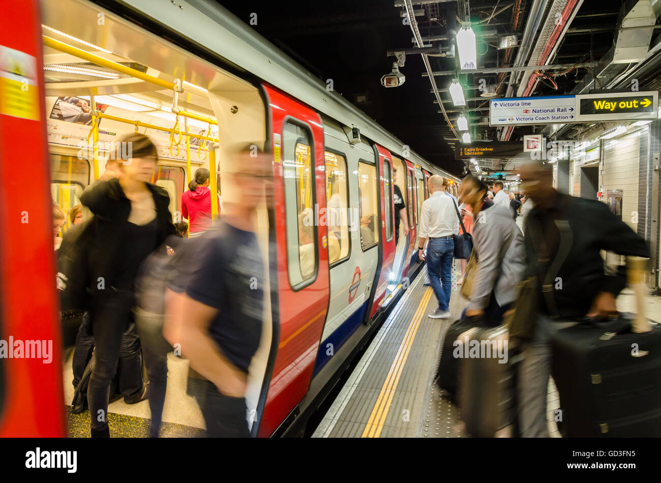 Passengers disembark and board a London Underground train at Victoria ...