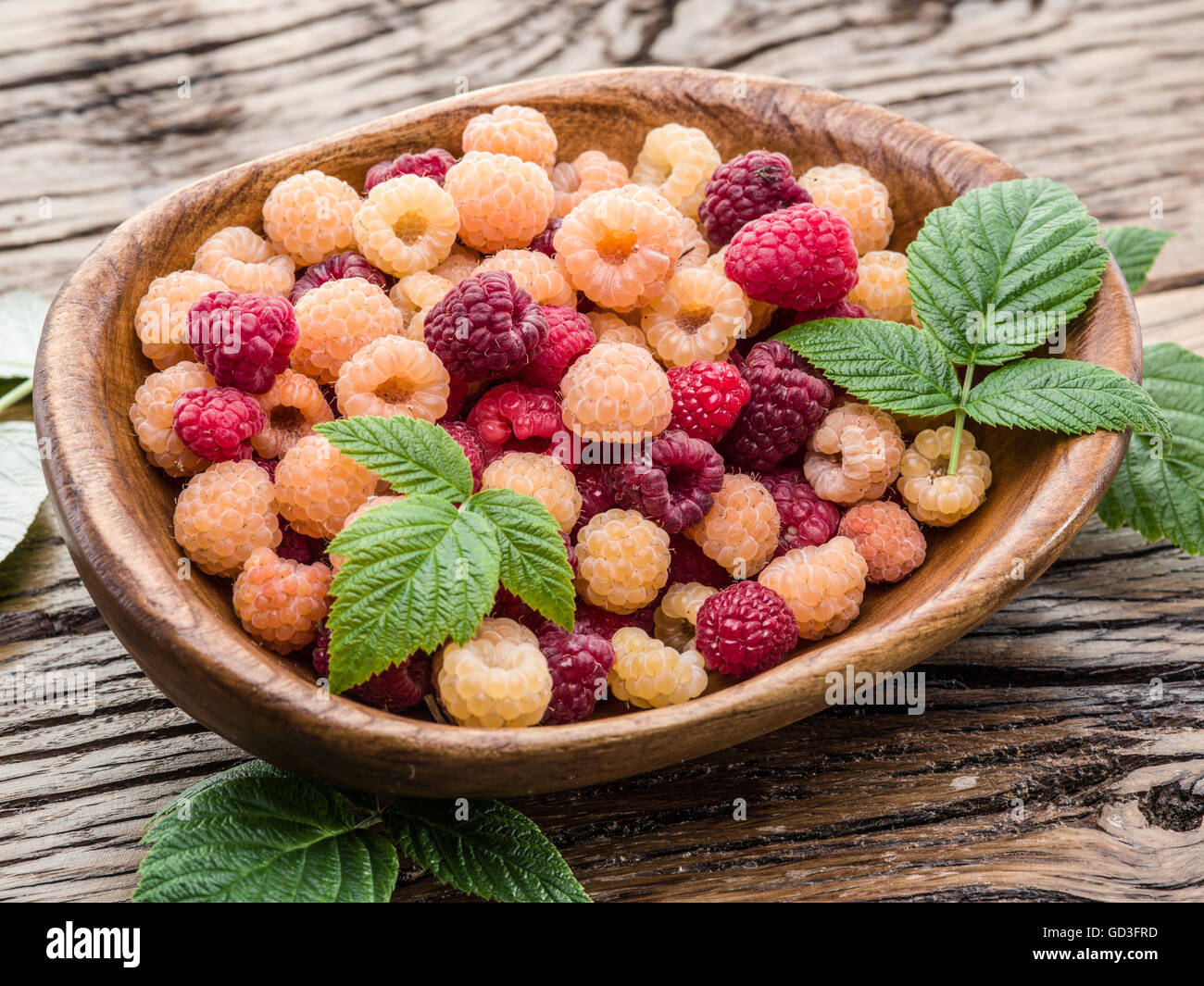 Raspberries in the wooden bowl on the table Stock Photo - Alamy