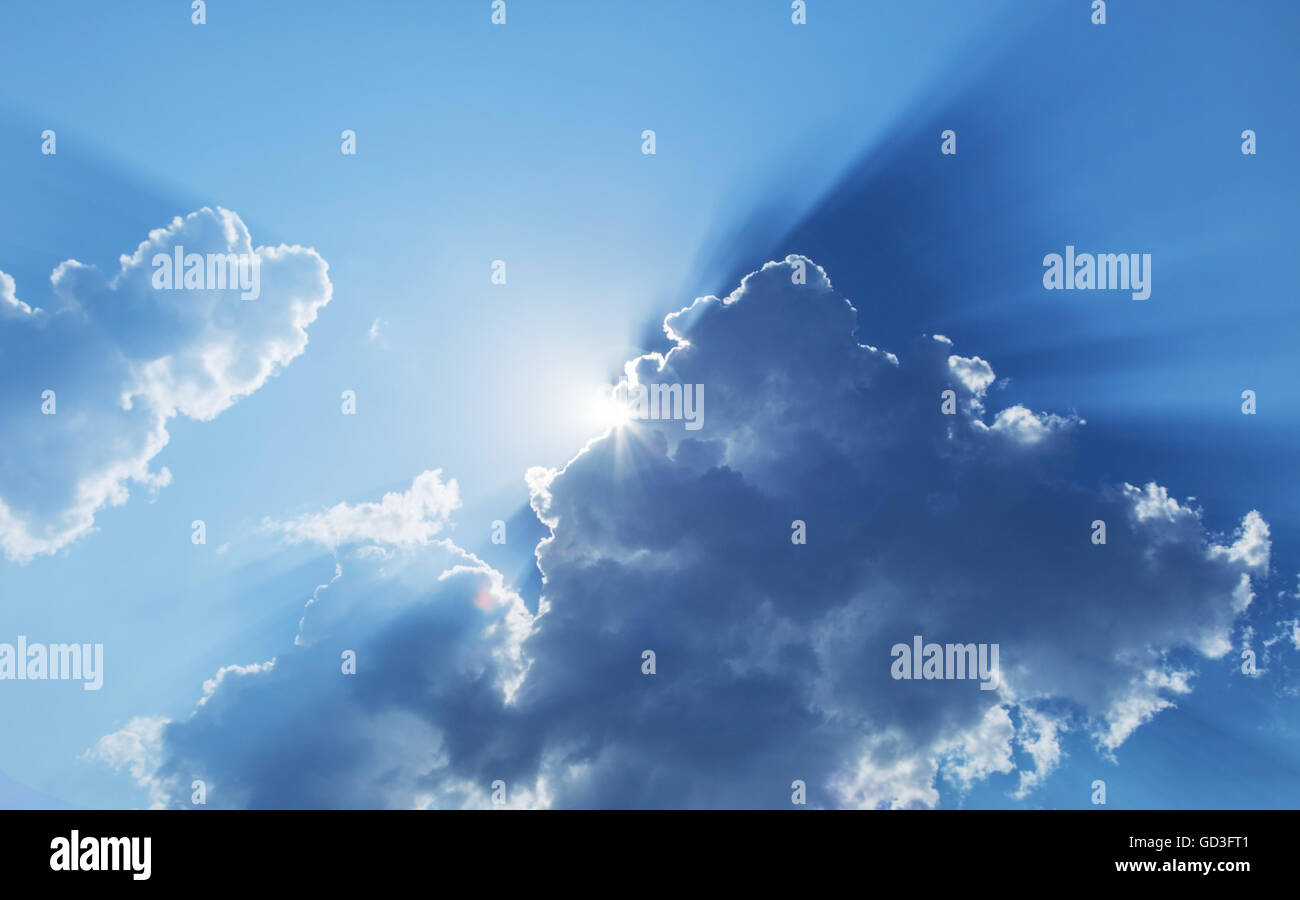 Sun slanting among from white clouds. Nature background Stock Photo - Alamy