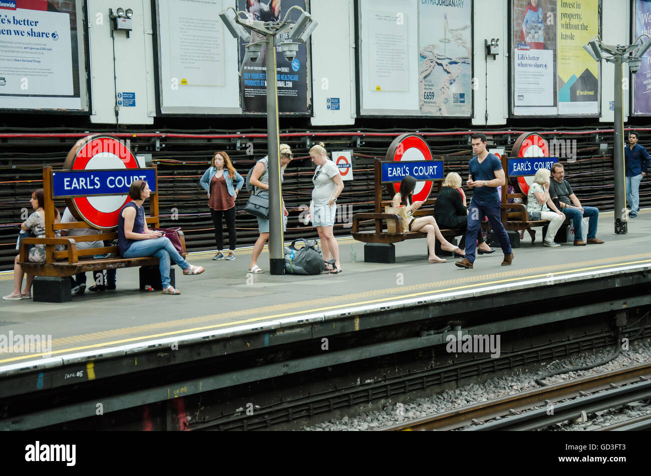 Passengers sit on benches at Earl's Court London Underground Station ...