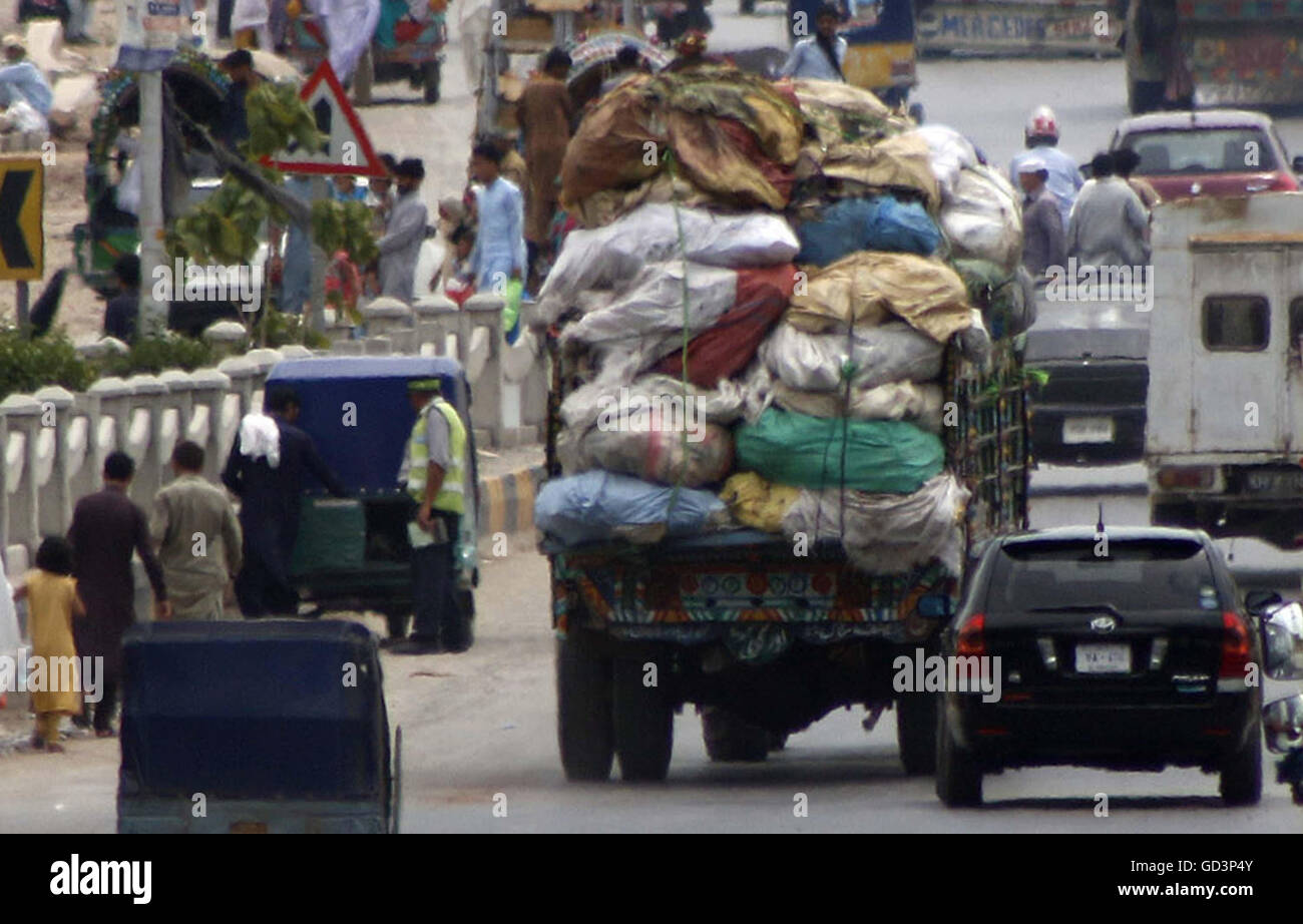 An over loaded vehicle violating the traffic rules passing through the ...