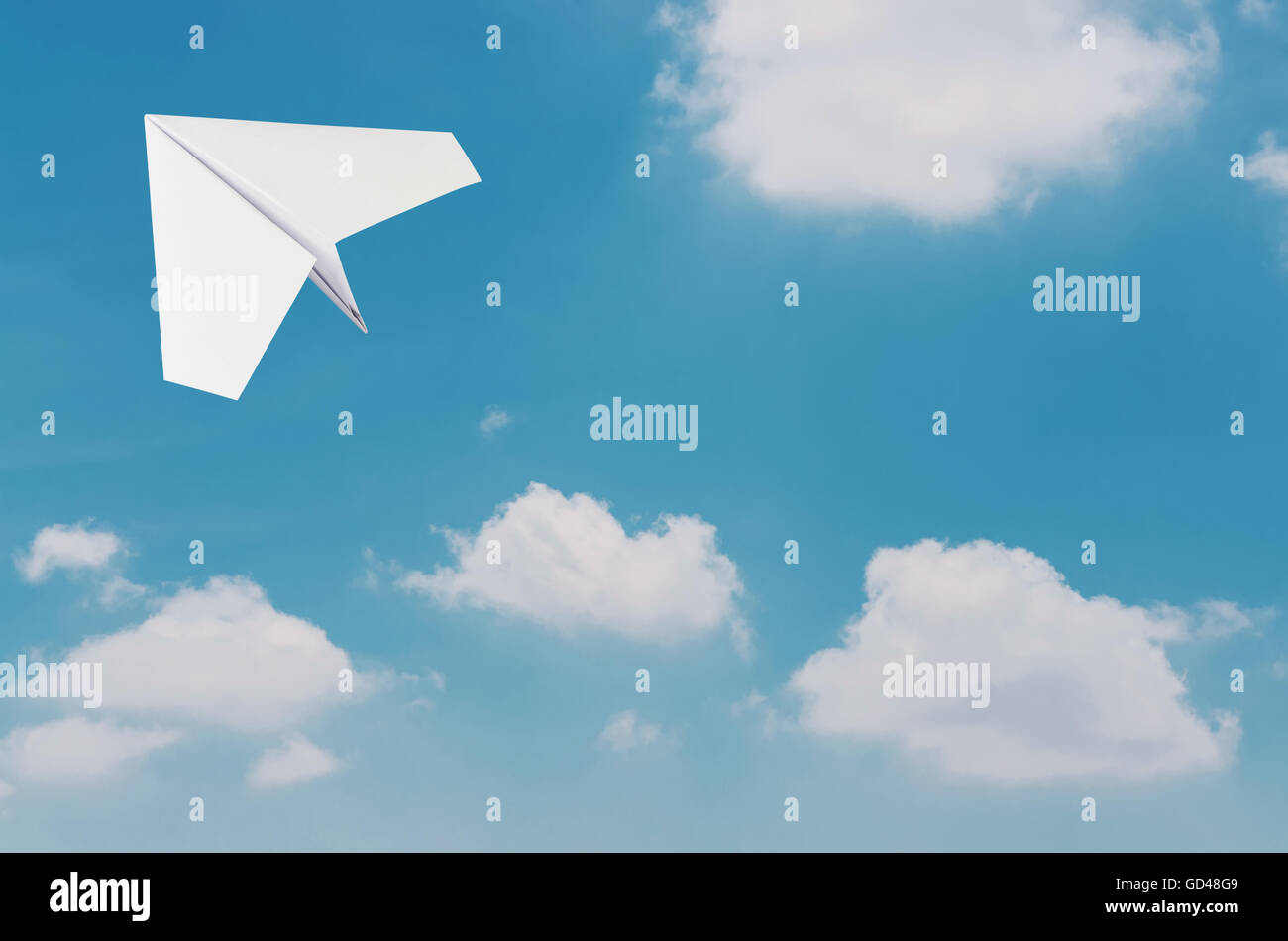 Paper plane flying over clouds with blue sky Stock Photo - Alamy